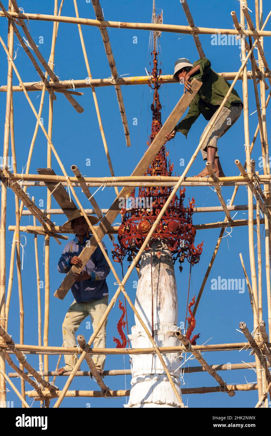Myanmar. Workmen on bamboo scaffold working on the spire of a temple ...