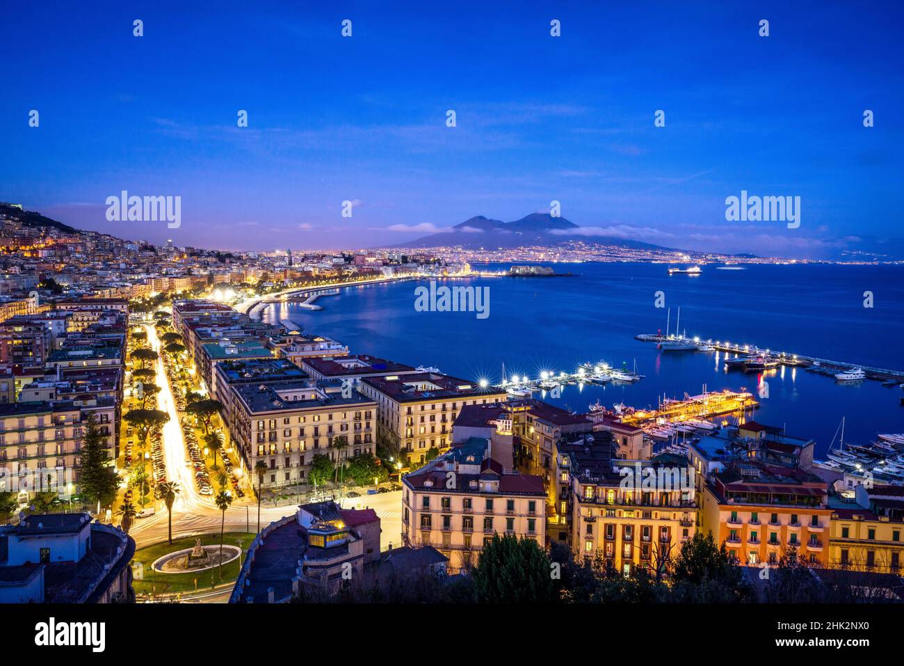 Europe, Italy, Naples. Overview of city with Mt. Vesuvius at sunset ...