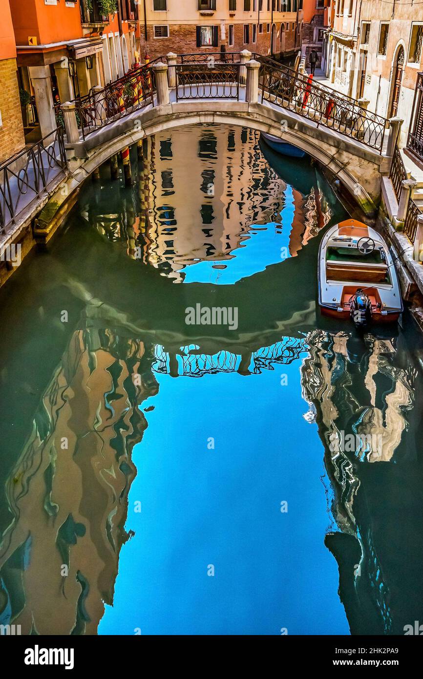 Colorful small canal and bridge creates beautiful reflections in Venice ...