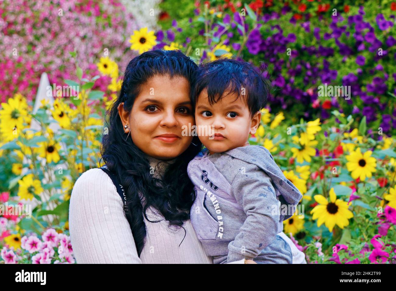 mom and baby standing in a flower garden Stock Photo - Alamy