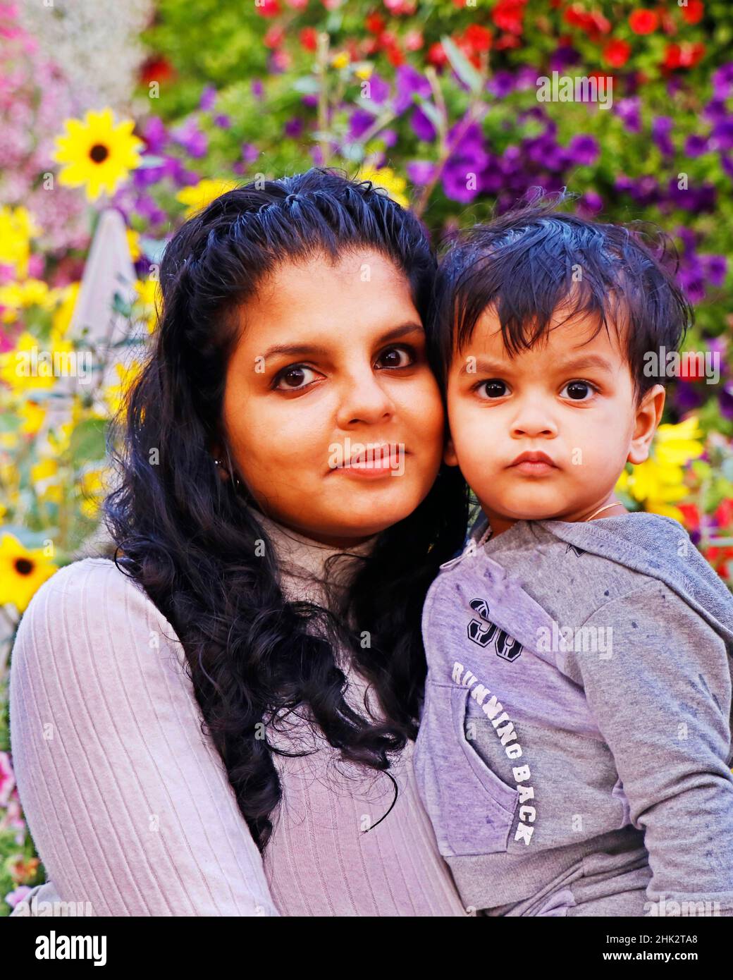 mom and baby standing in a flower garden in close up Stock Photo - Alamy