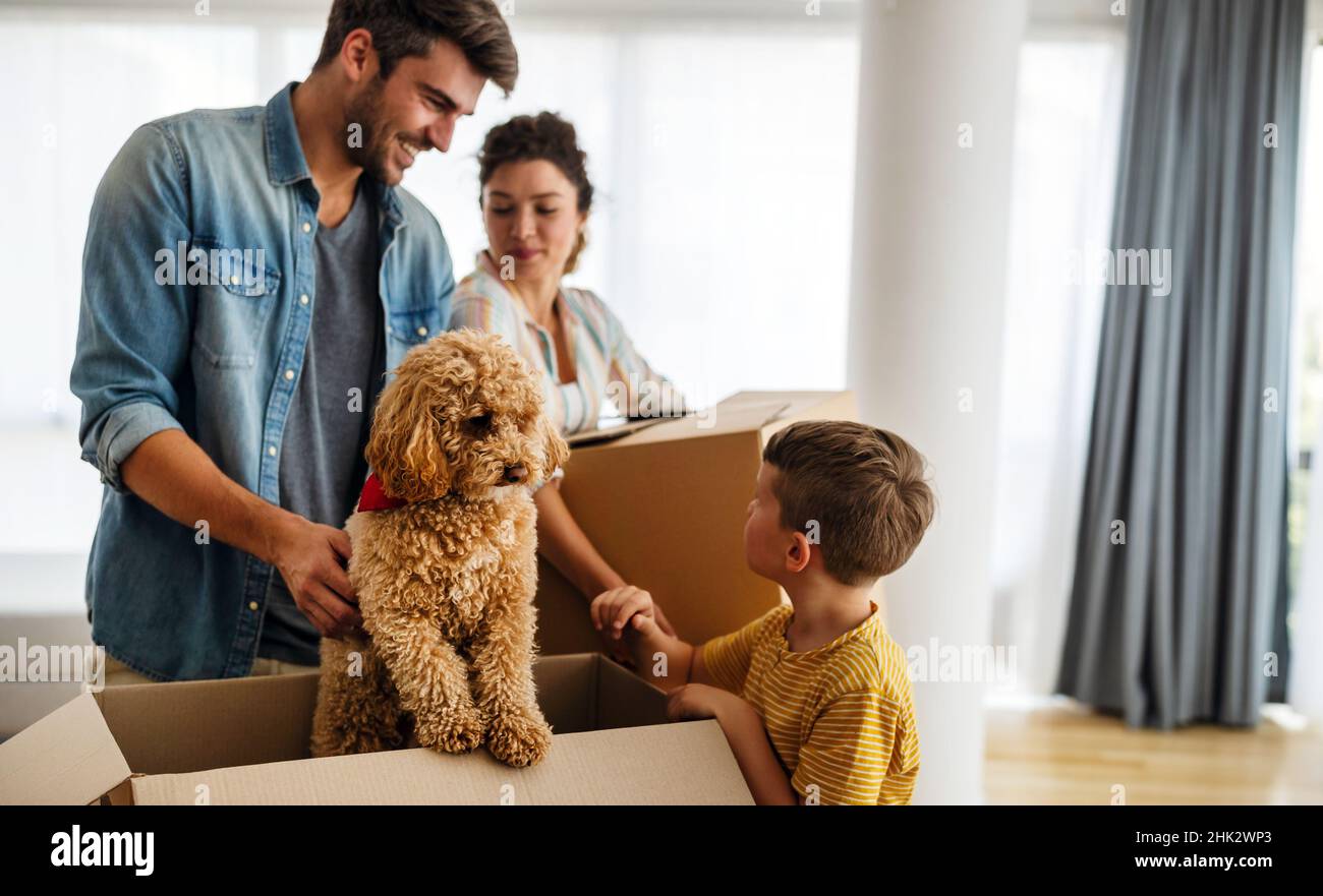 Happy young family unpacking cardboard boxes at new home Stock Photo ...