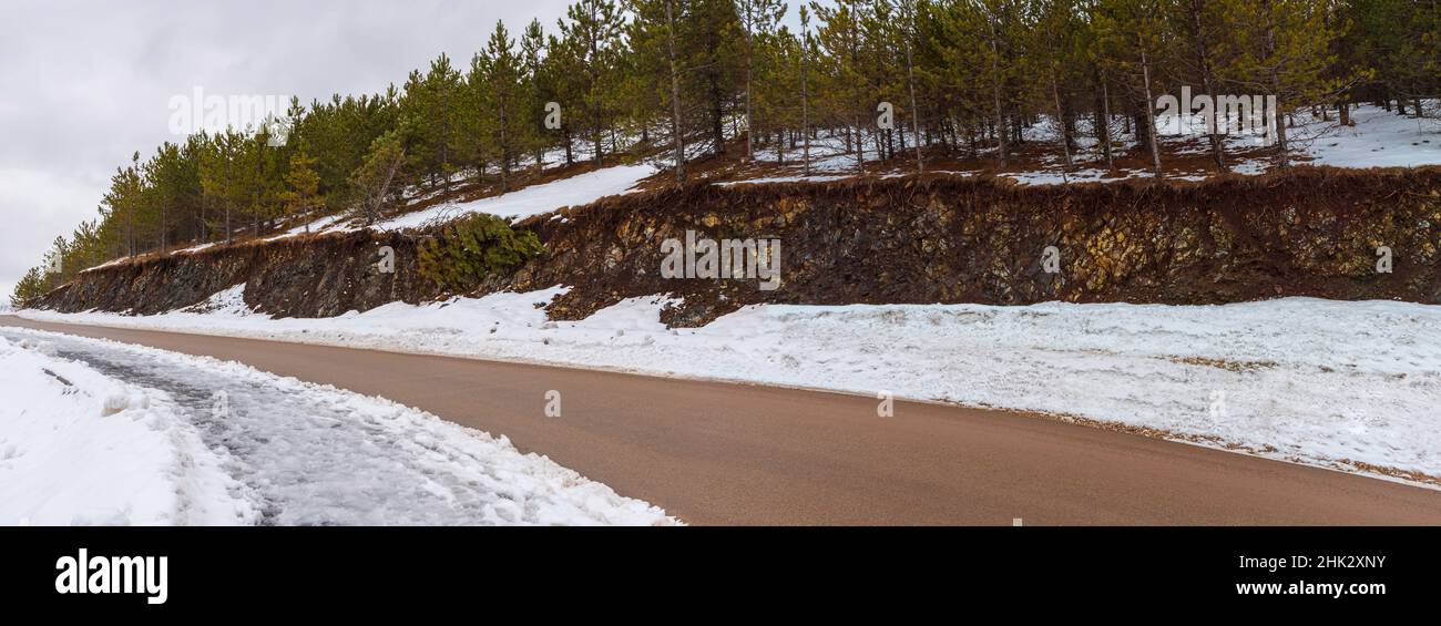 Muddy asphalt snow rural mountain road with cloudy sky Stock Photo - Alamy