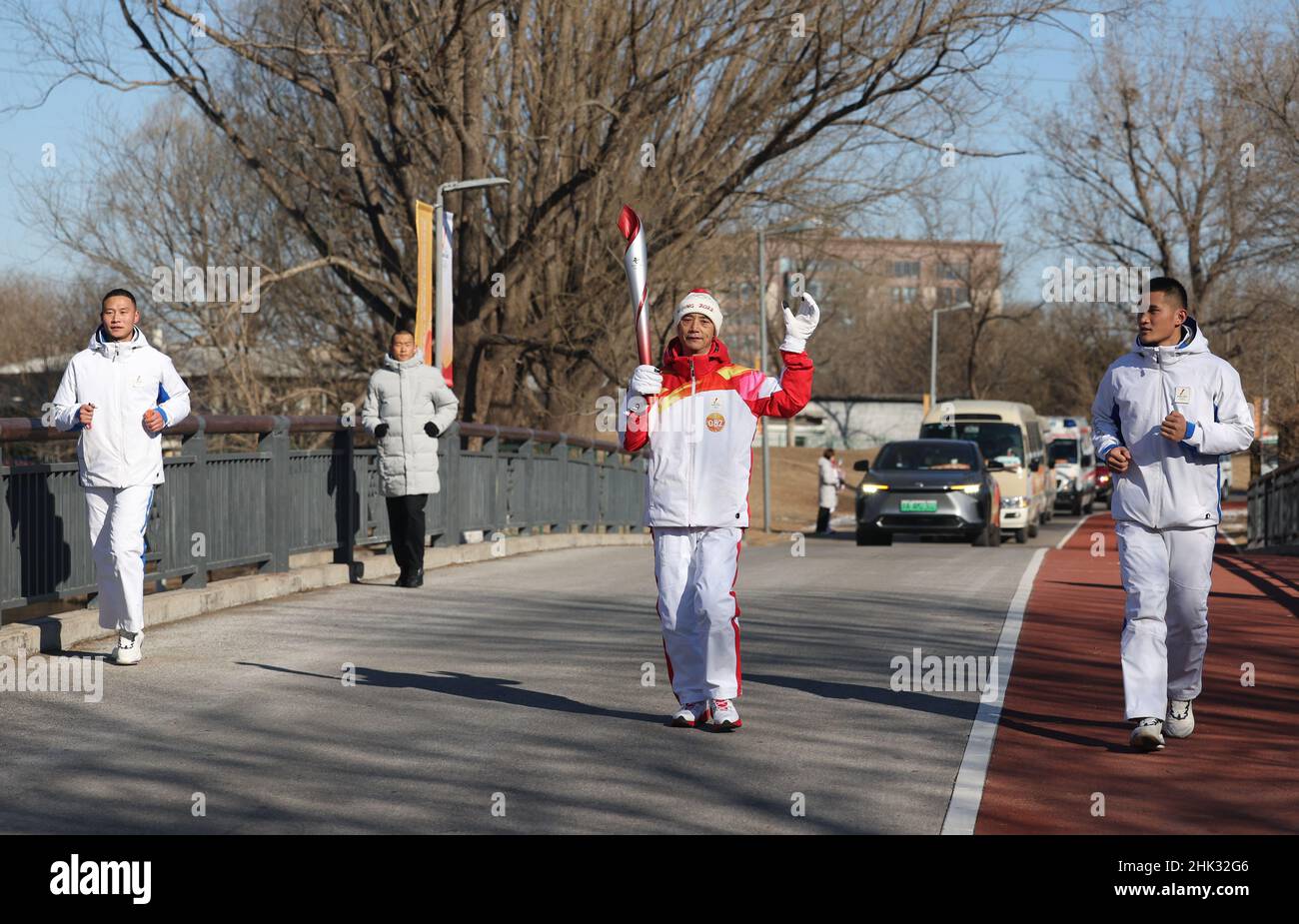 Beijing, China. 2nd Feb, 2022. Torch bearer Fu Xisheng runs with the torch during the Beijing ...