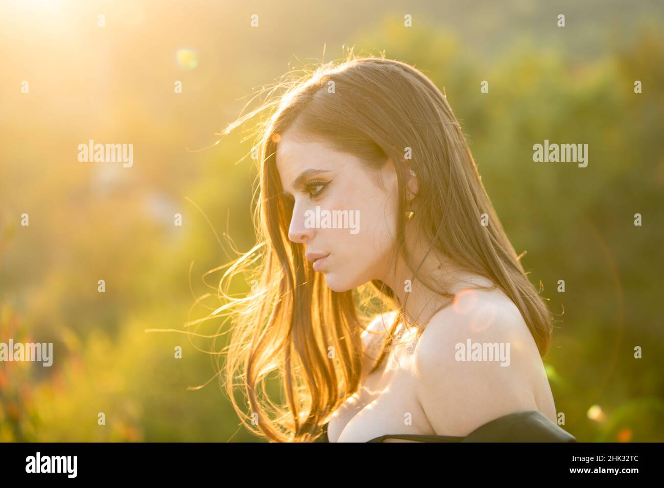 Portrait of beautiful young woman looking eways in summer park. Outdoor ...