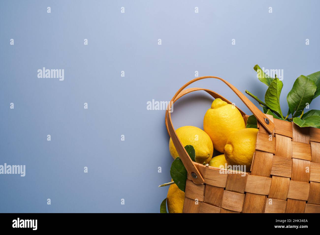 fresh lemons with green leaves in Cotton eco bag on blue background ...