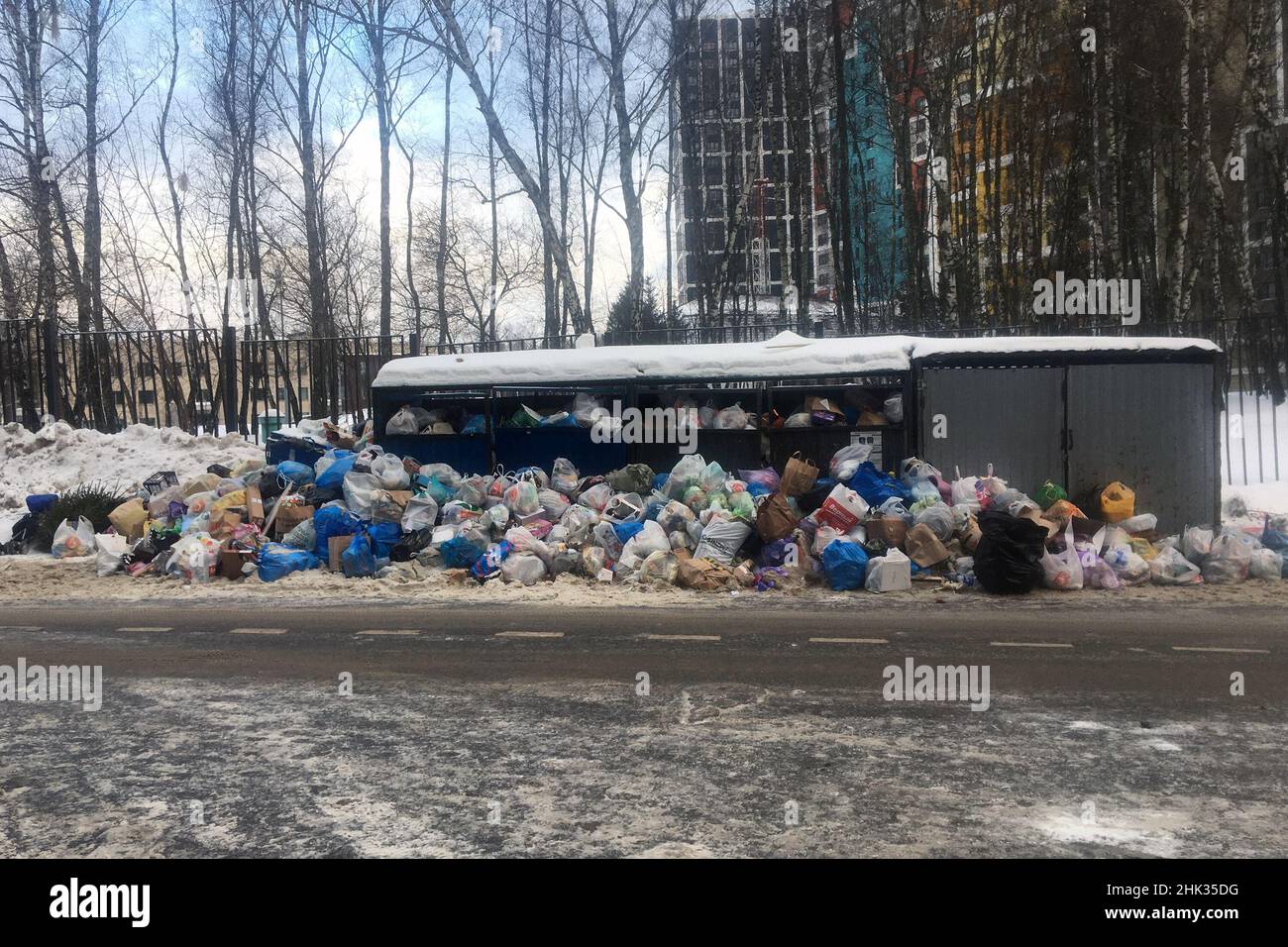 Garbage cans near littered with household garbage in plastic bags ...