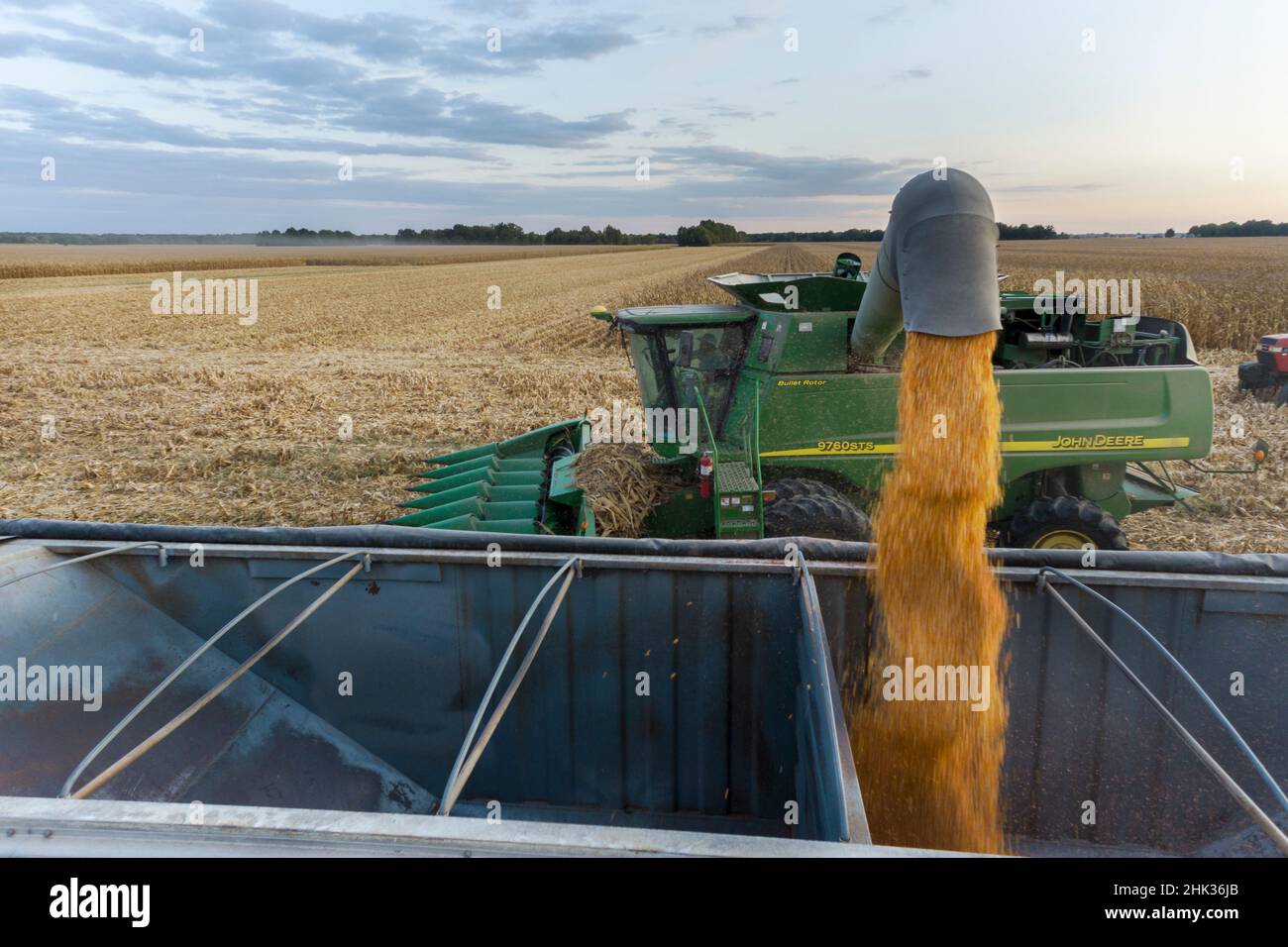 Aerial view of combine harvesting corn and unloading into gravity ...
