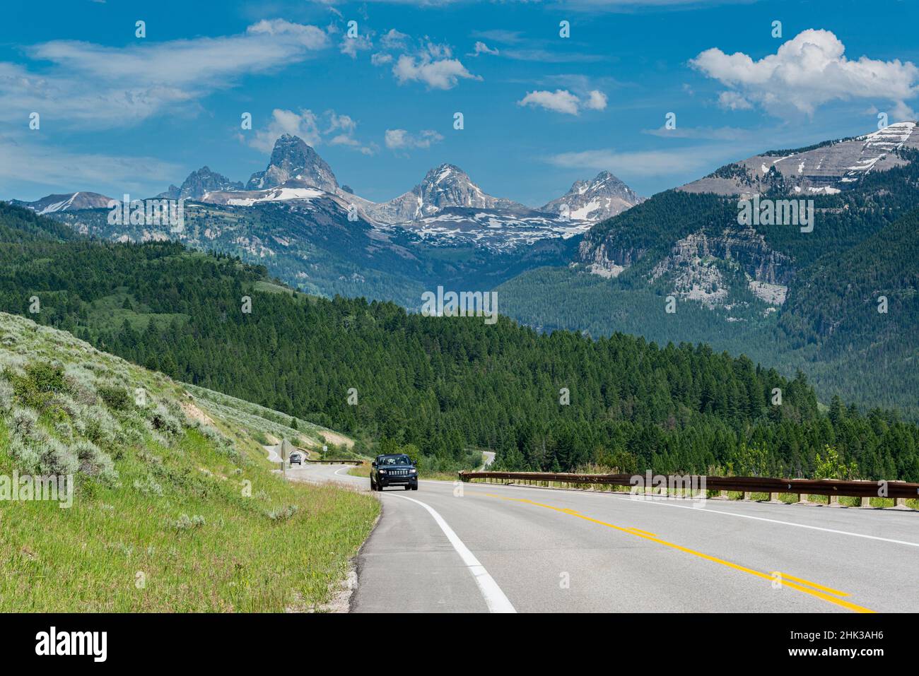USA, Wyoming. Car on Ski Hill Road with view of Grand Teton, west side ...