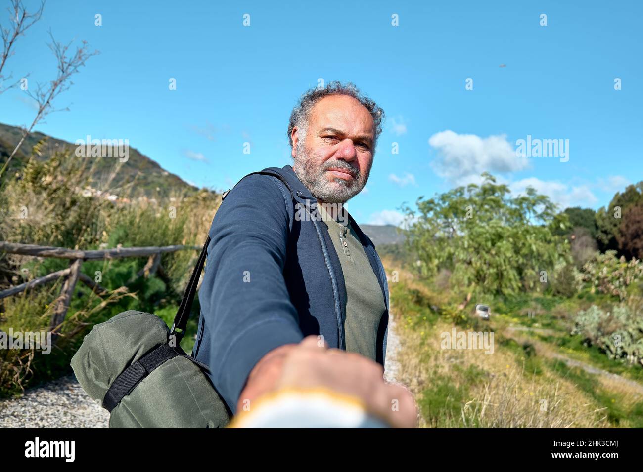 Follow me. Man holds and pulls the photographer's hand while walking on ...
