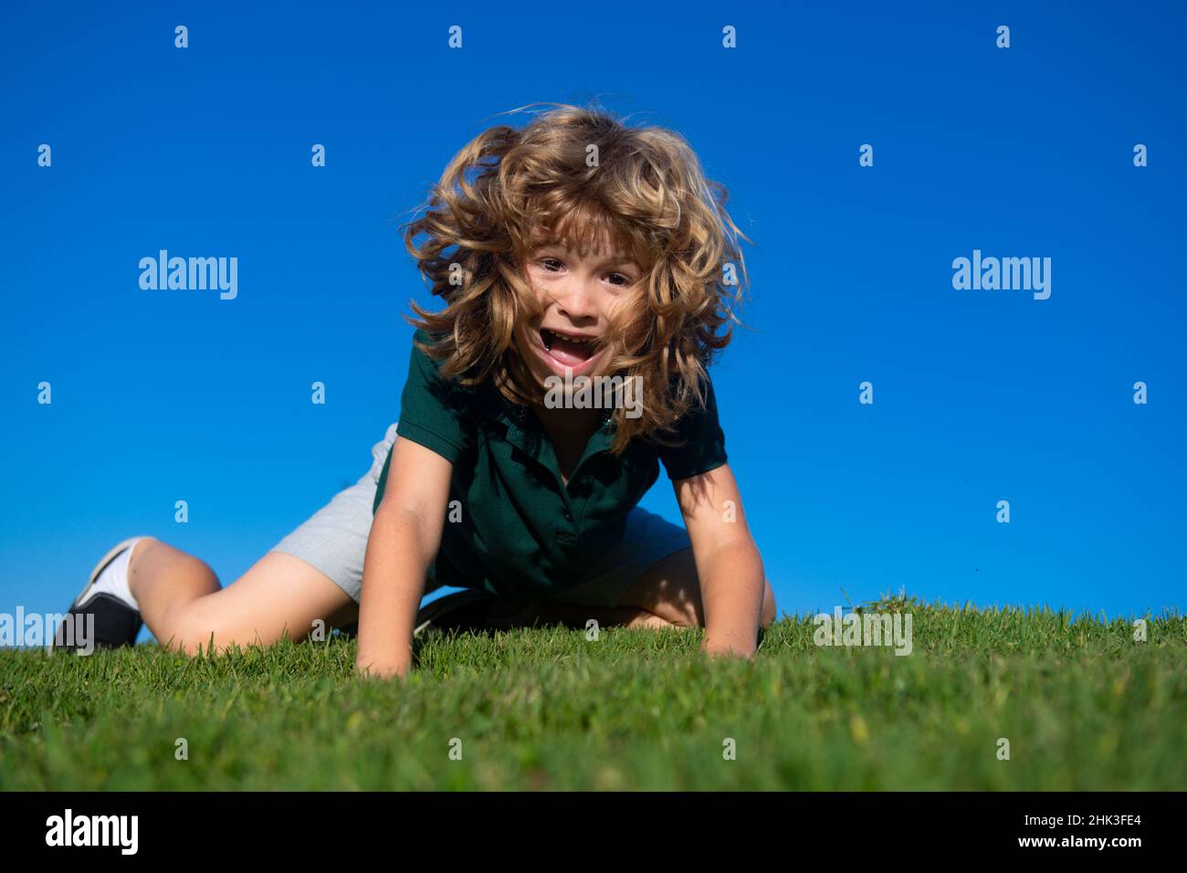 Portraits of happy kids playing and laying on grass outdoors in summer ...