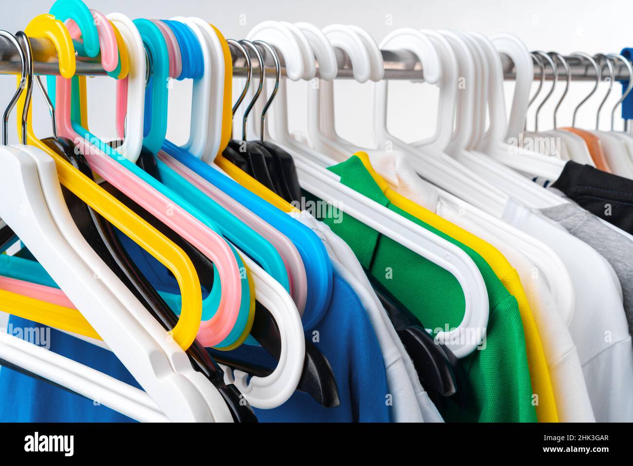 Clothes hang on clothing rack over white background Stock Photo - Alamy