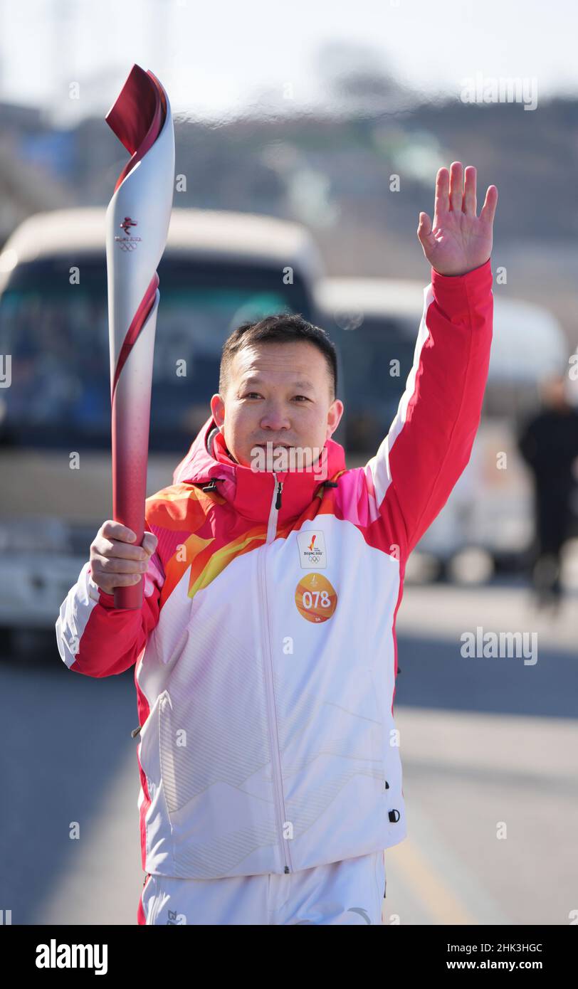 Beijing, China. 2nd Feb, 2022. Torch bearer Qu Dechang runs with the torch during the Beijing ...