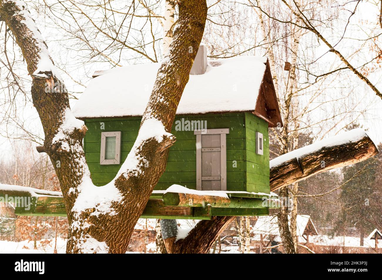 Wooden small tree house in winter during a snowfall. Building in the ...