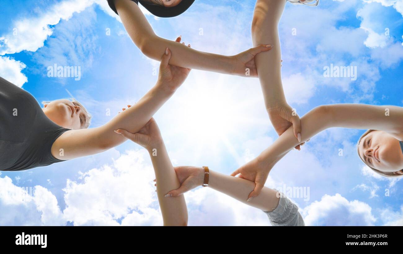 Friends join their hands by the wrist and make a circle against the ...