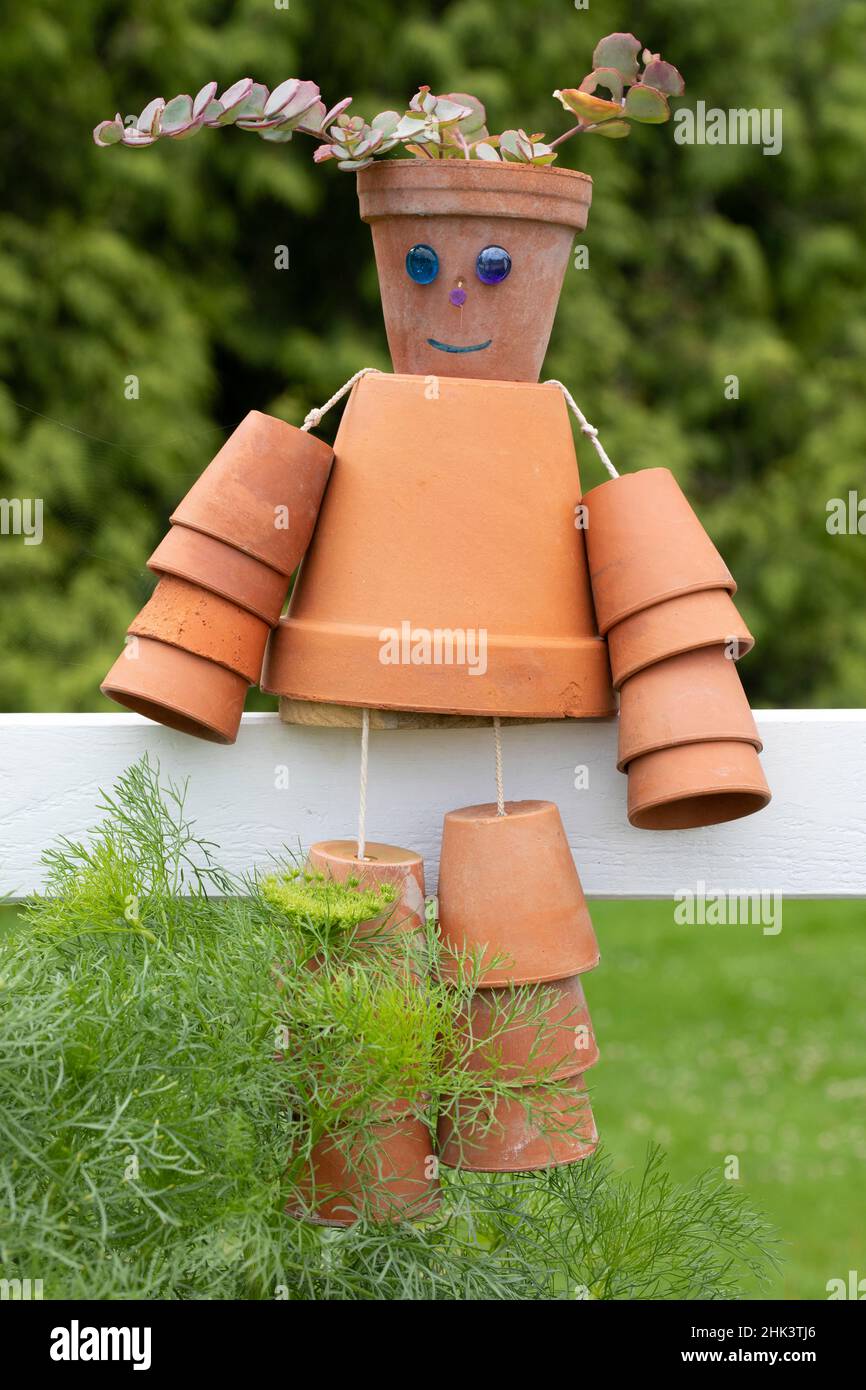 Character in terracotta pots on a fence Stock Photo - Alamy