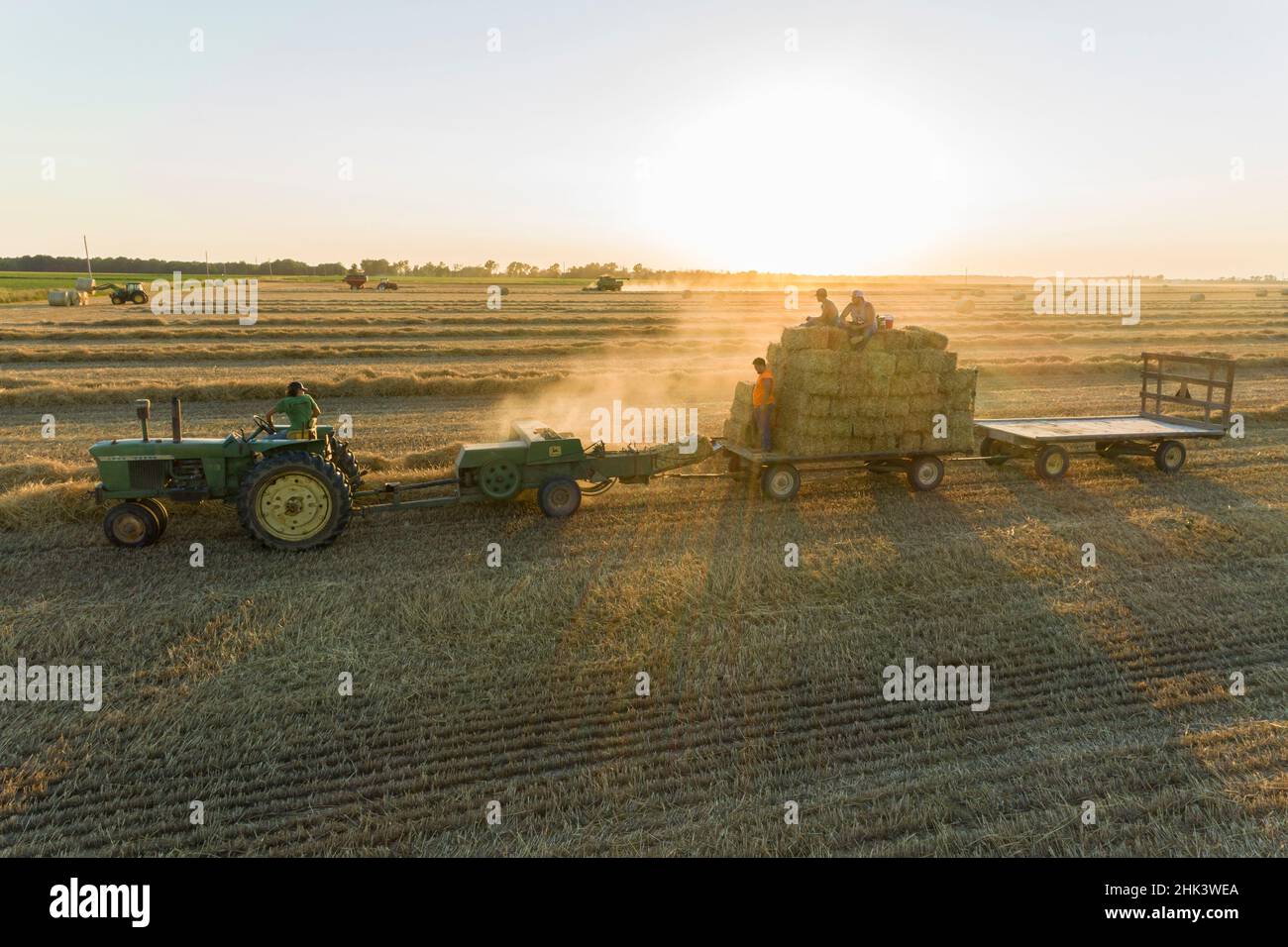 Aerial view of tractor baling wheat straw at sunset, Marion County ...
