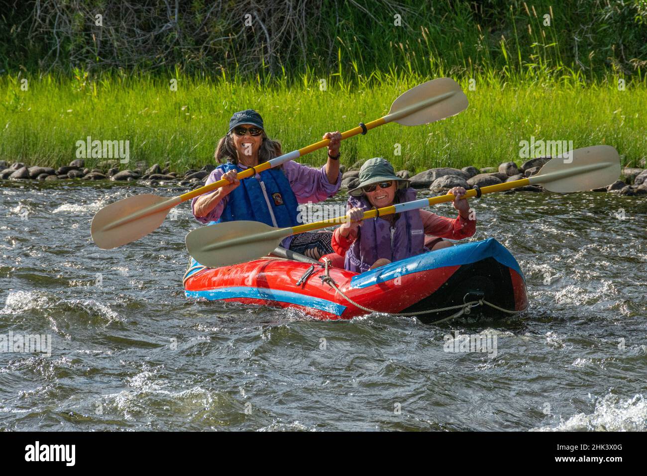 USA, Montana. Two women enjoying a paddle in inflatable kayak, Big Hole ...