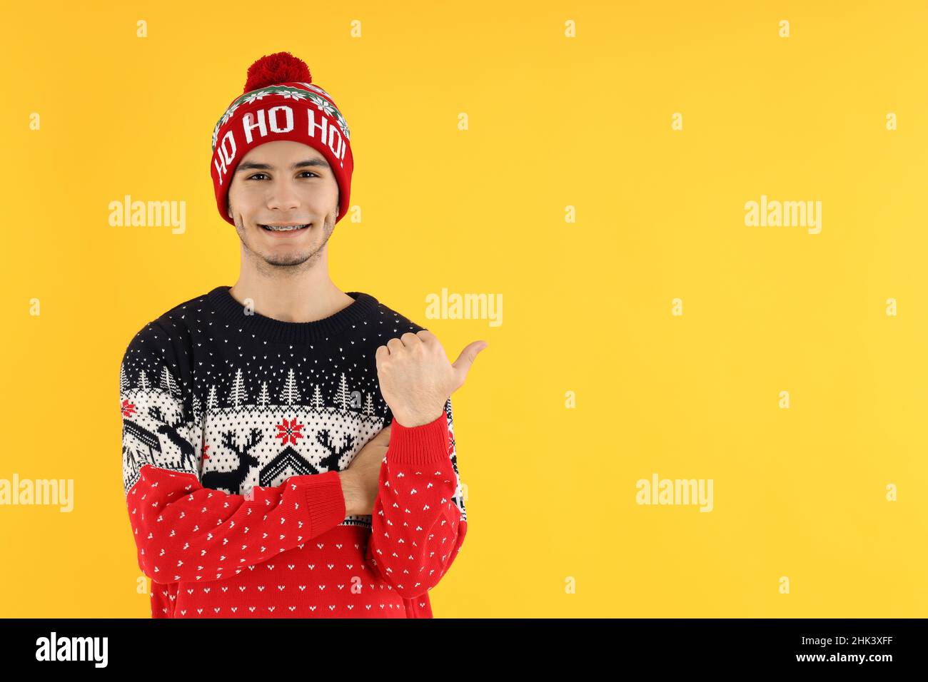 Attractive guy in Christmas sweater on yellow background Stock Photo ...