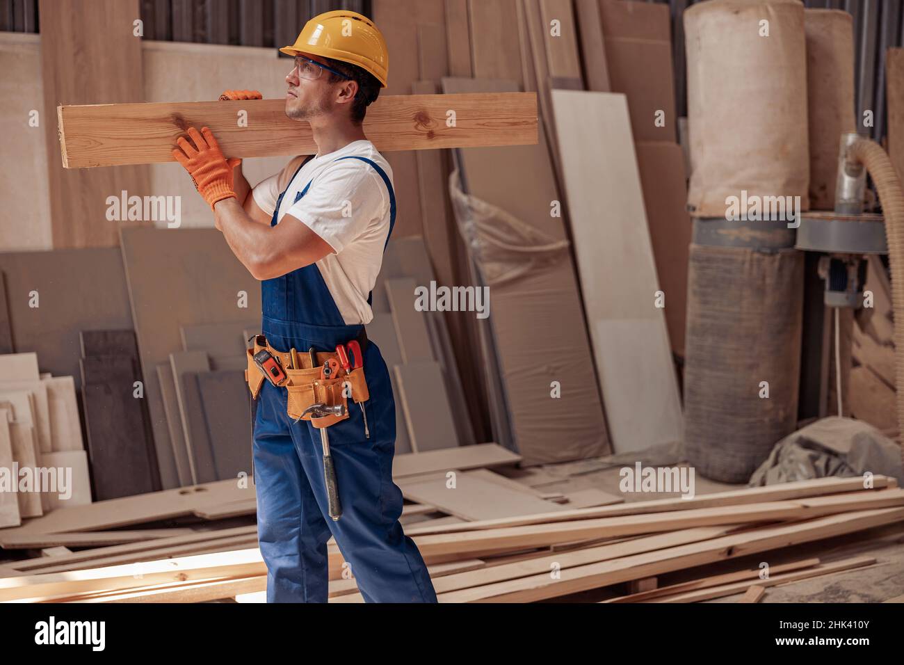 Male worker carrying timber wood plank at construction site Stock Photo ...
