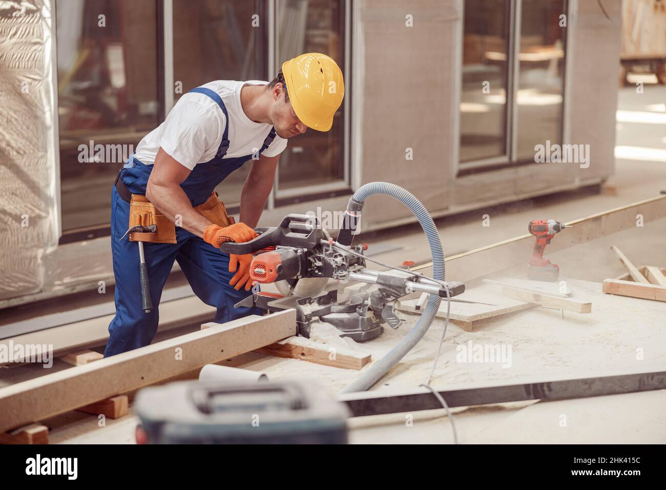 Male builder using wood cutting circular saw machine Stock Photo - Alamy