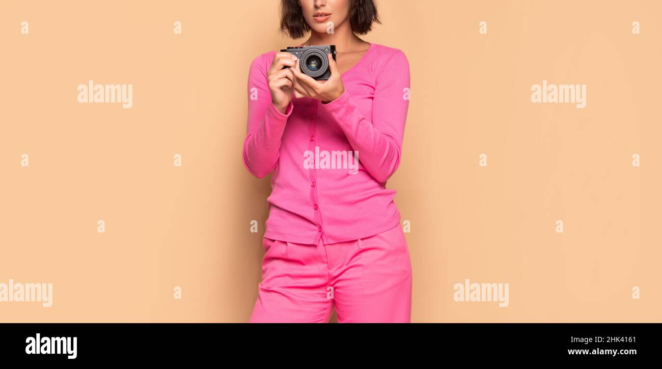 Woman photographer crop view holding photo camera in hands beige ...