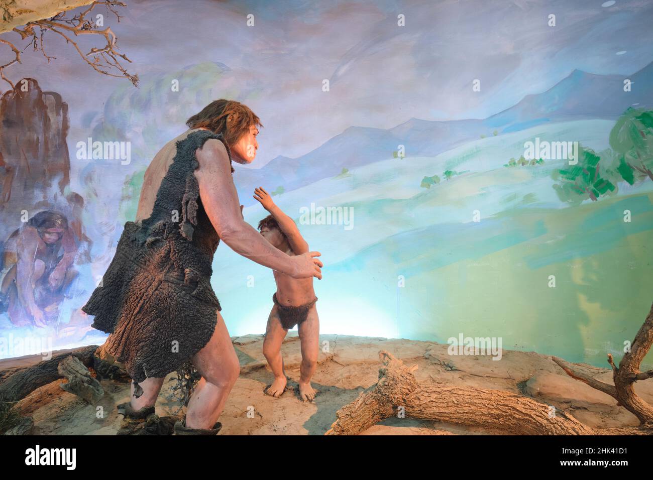 A large diorama featuring people from the stone age. Father and child ...