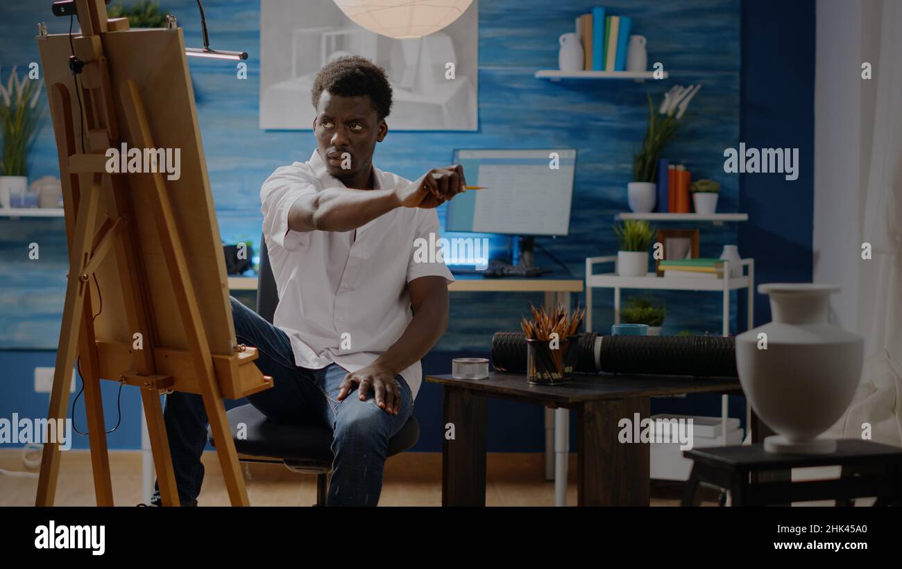 African american young adult using art tools for drawing sitting in ...