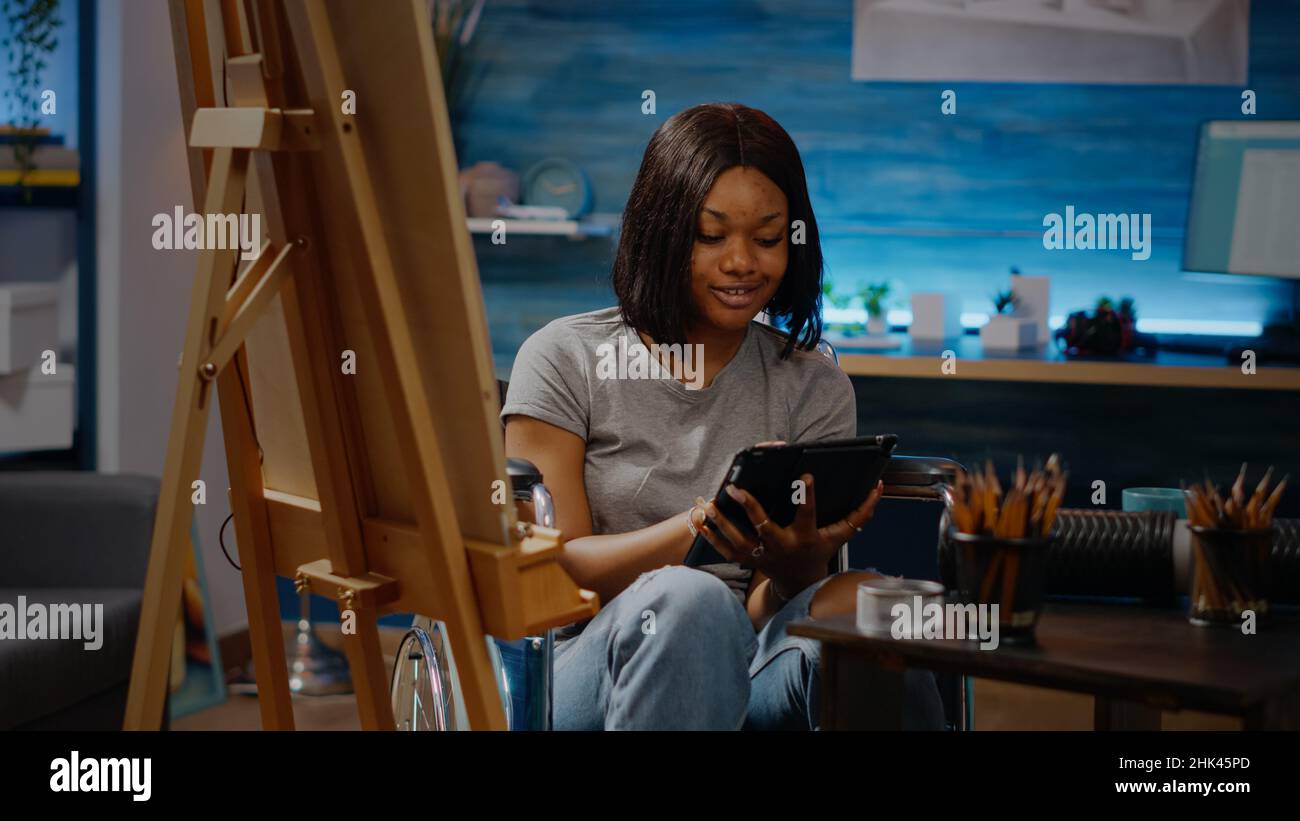 Paralyzed african american artist using digital tablet at art studio ...