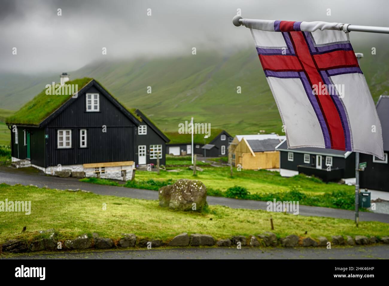 Typical Faroese village with traditional grass roof houses and the flag ...