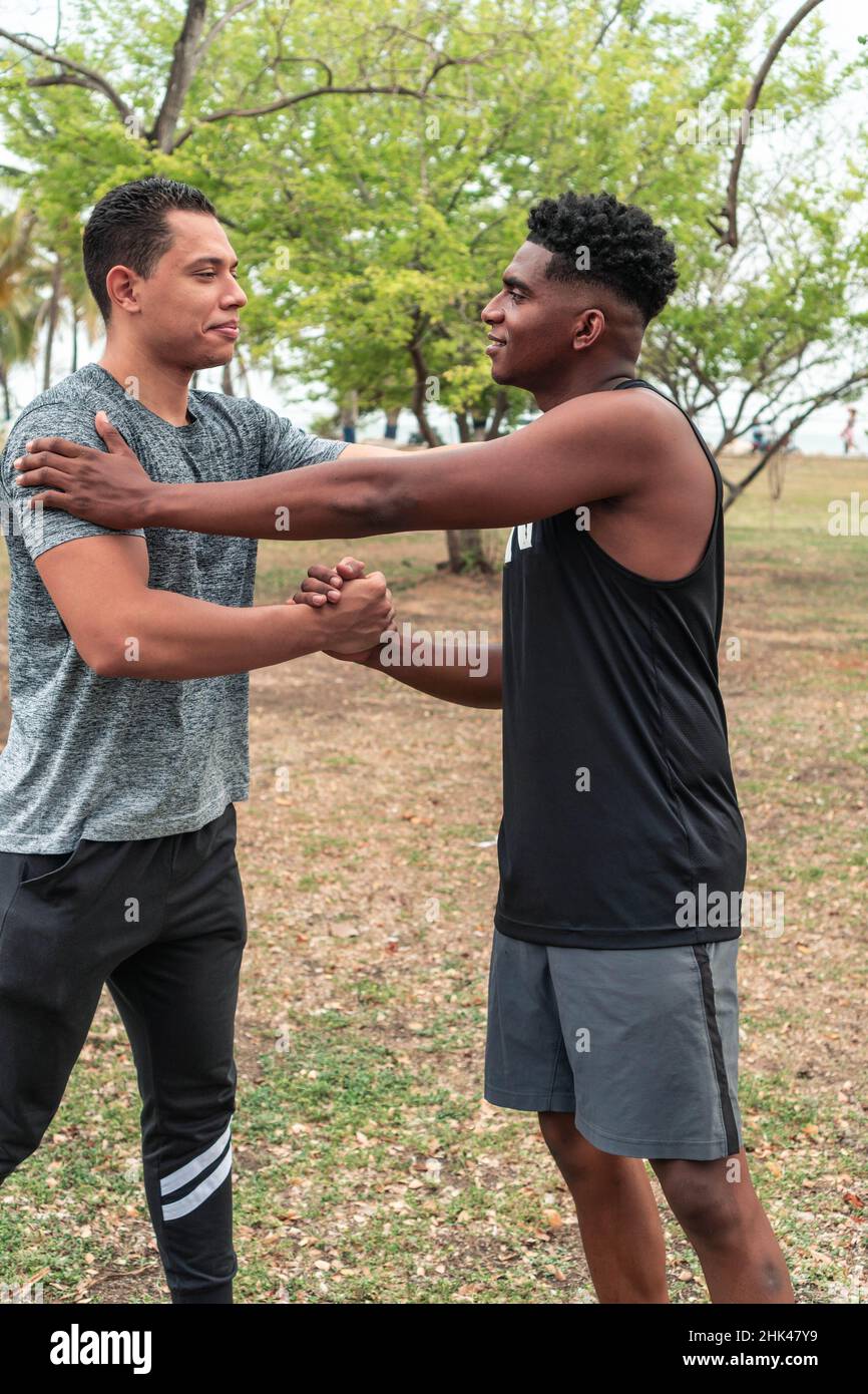 Men in sportswear in the park shaking hands with smiling faces Stock ...