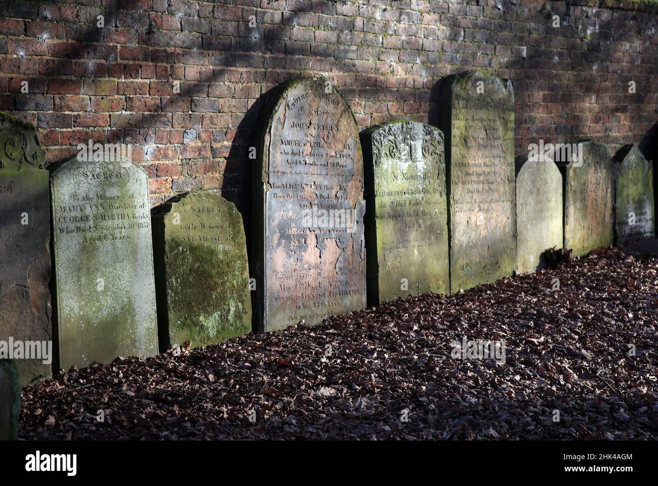 Gravestones placed against a wall in the grounds of St Mary and all ...