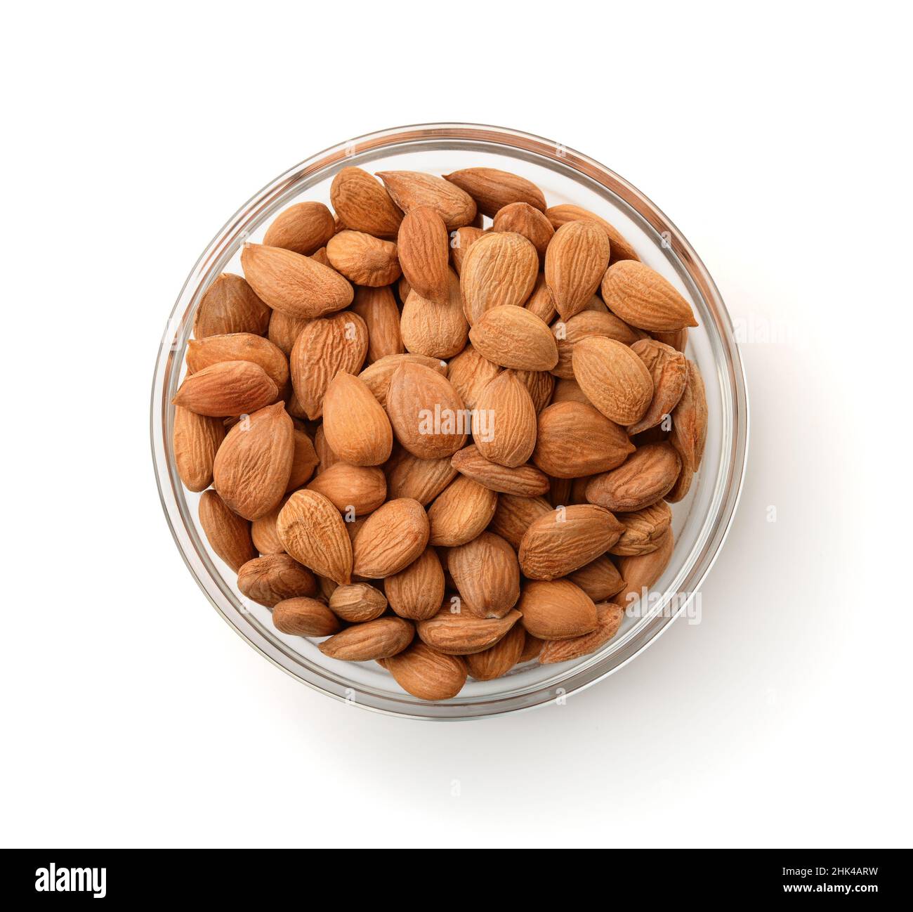 Top view of peeled apricot kernels in glass bowl isolated on white ...