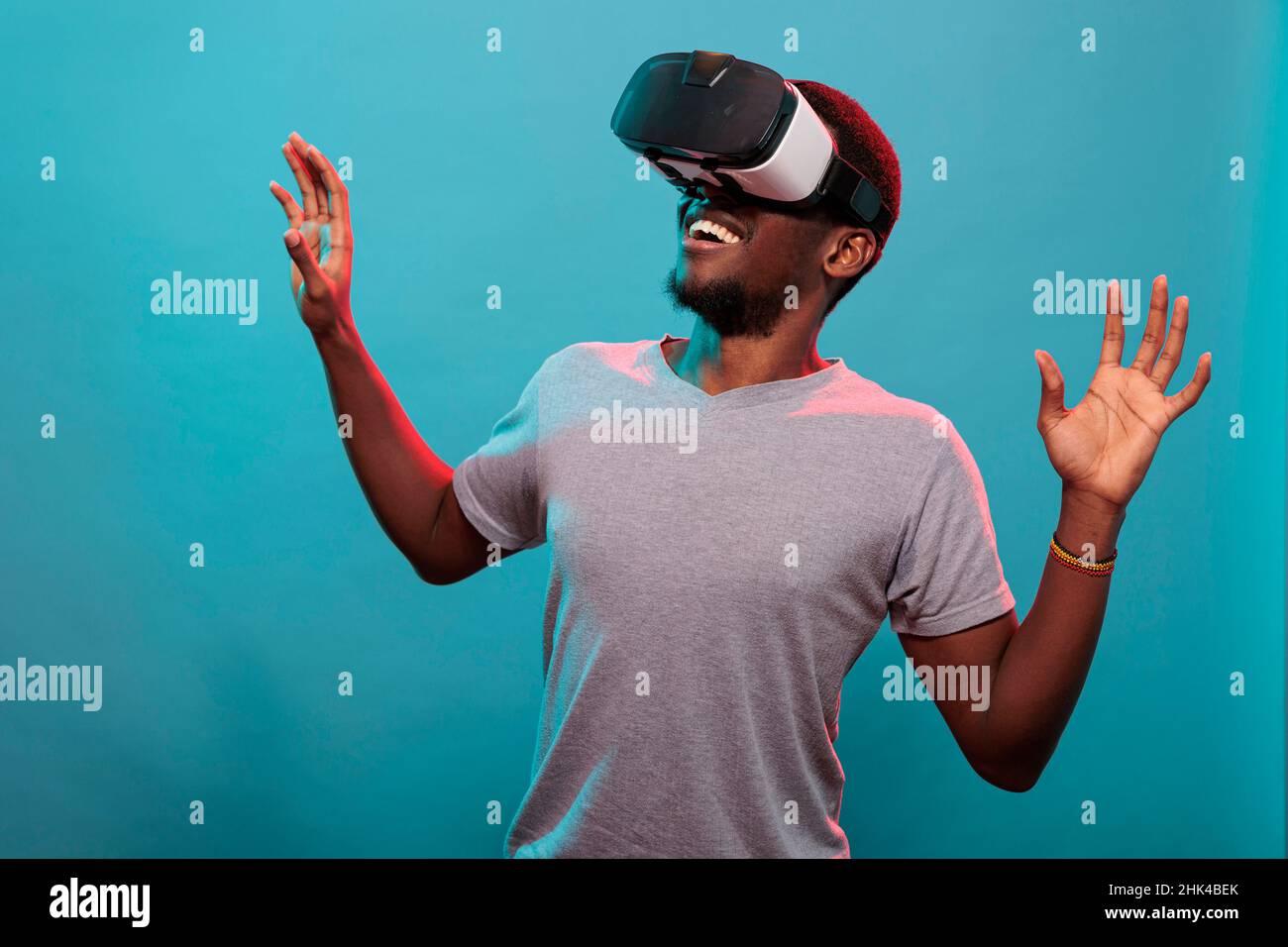 Modern adult wearing vr goggles with video interaction, standing over ...