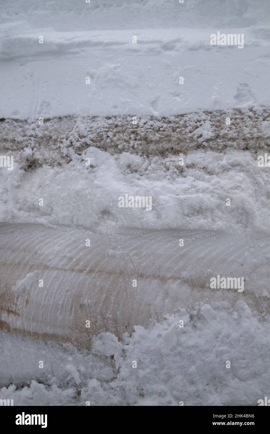 Frosted snow block with snowplow tracks on the road shoulder, abstract ...
