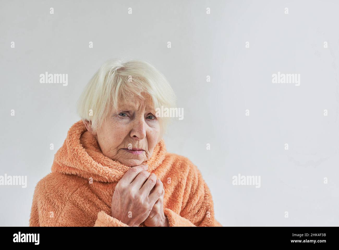 senior ill woman freezing cold at home. Health care, crisis, oldness ...