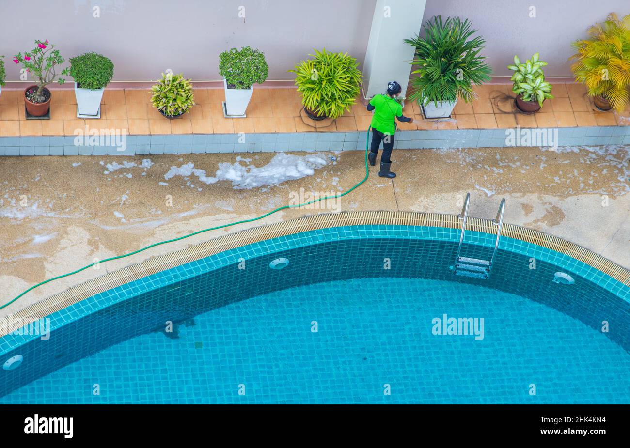 A cleaning crew at work maintaining and tidying up the pool of a ...
