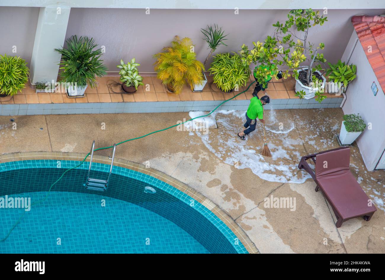 A cleaning crew at work maintaining and tidying up the pool of a ...