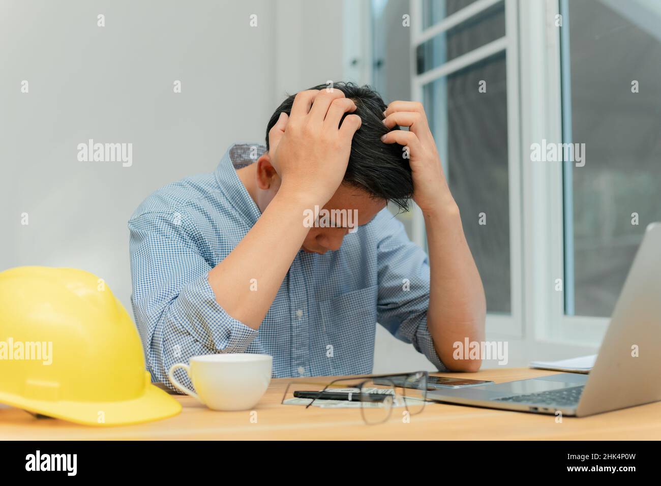 A male engineer sitting in the office is stressed Stock Photo - Alamy
