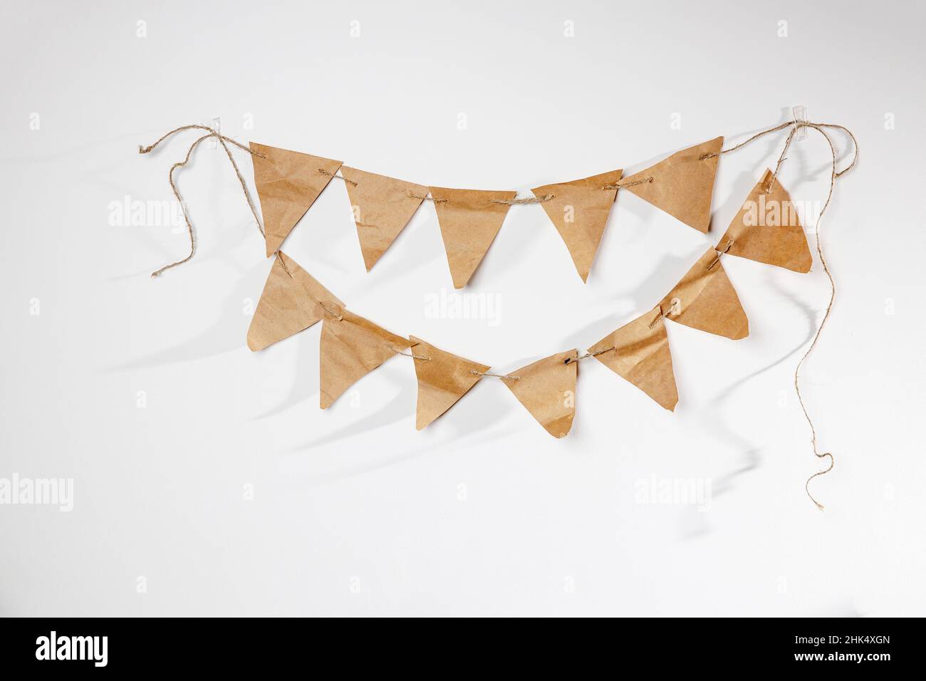 Homemade garland of craft paper flags with the pace for text hanging on ...