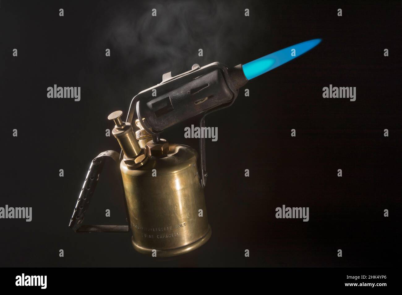Blow torch with blue flame and smoke on black background Stock Photo ...