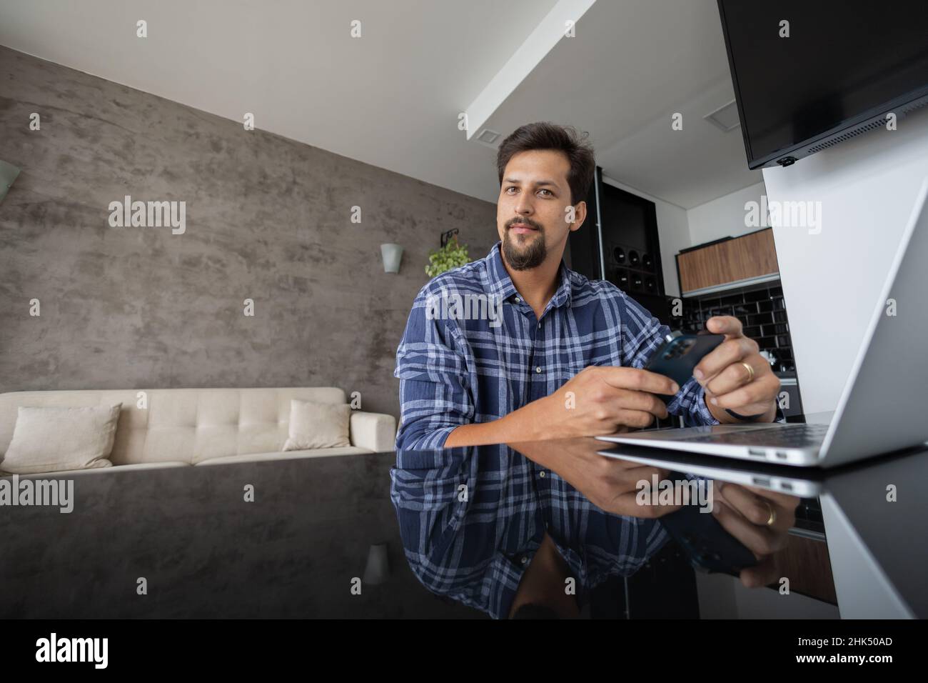 Young white man working at home with laptop on desk. Home office ...