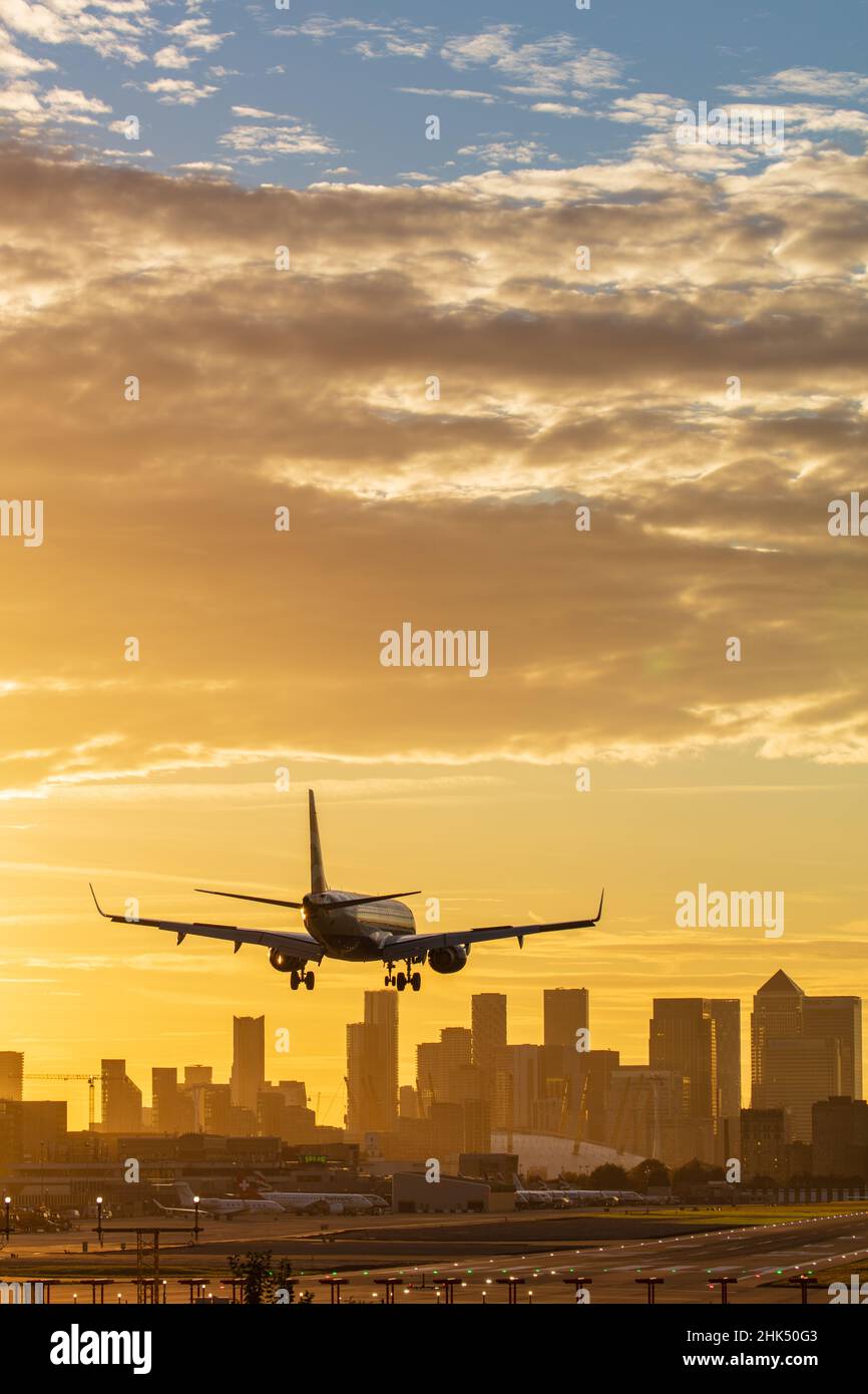 Aircraft landing at London City Airport at sunset, with Canary Wharf ...