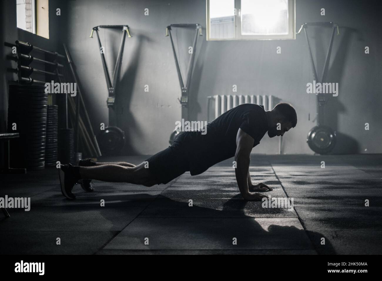 Sportsman Do Exercises at Big Dark Gym Stock Photo - Alamy
