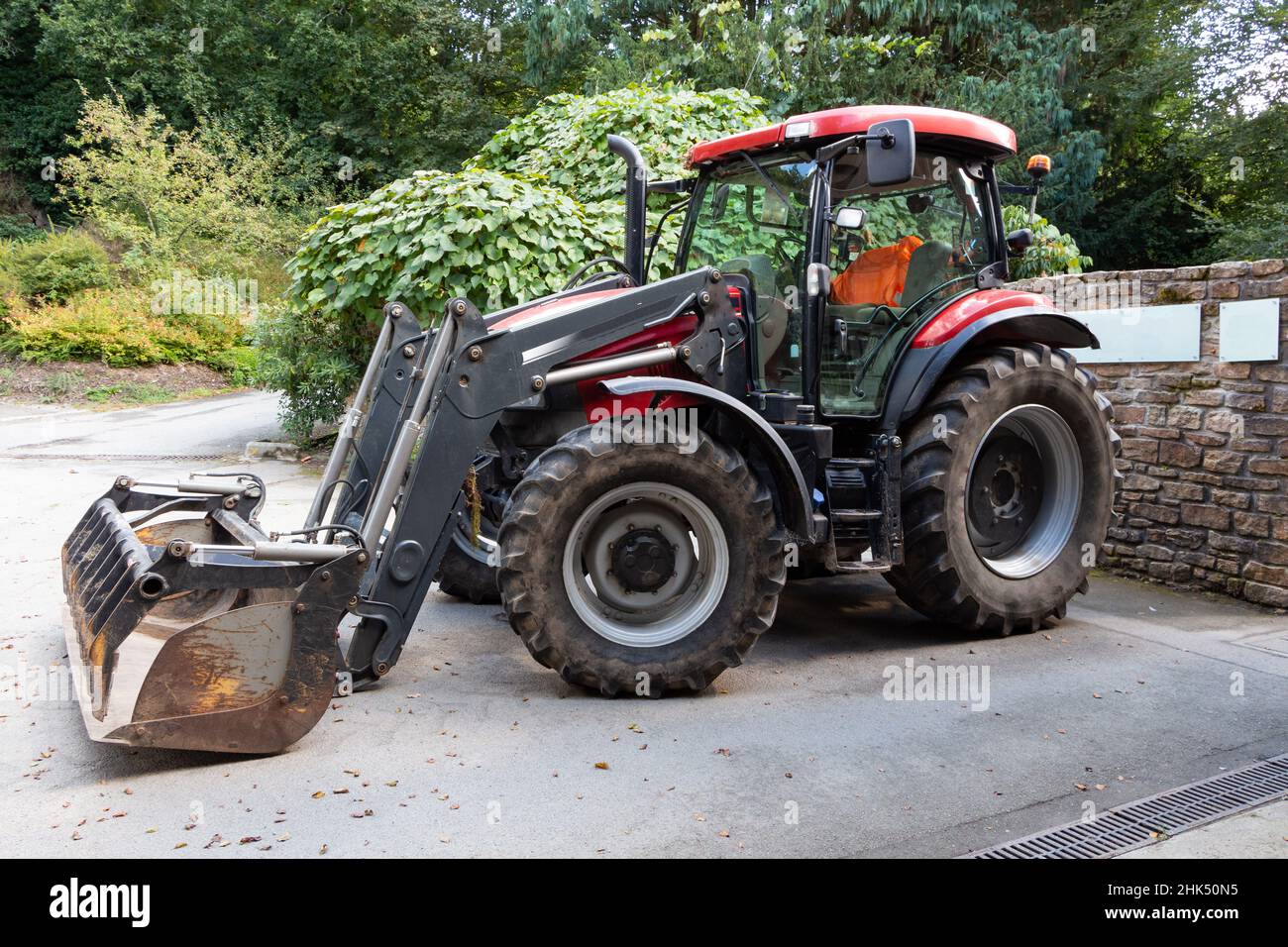 Tractor with loader bucket parked in the backyard of a farm Stock Photo ...