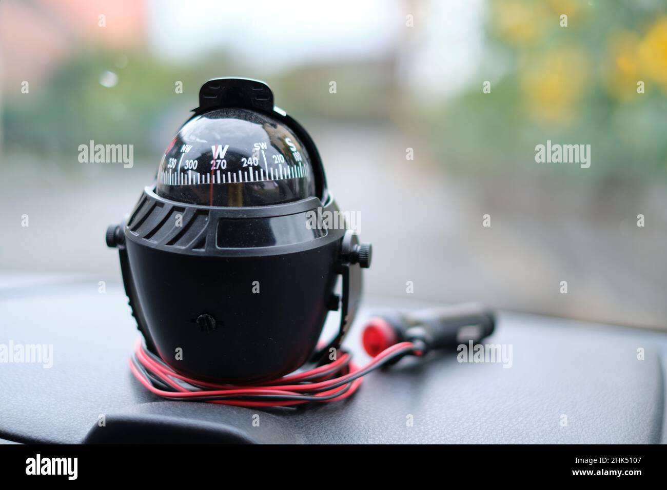 Close up of a dashboard compass mounted in a car. Analog navigation and ...