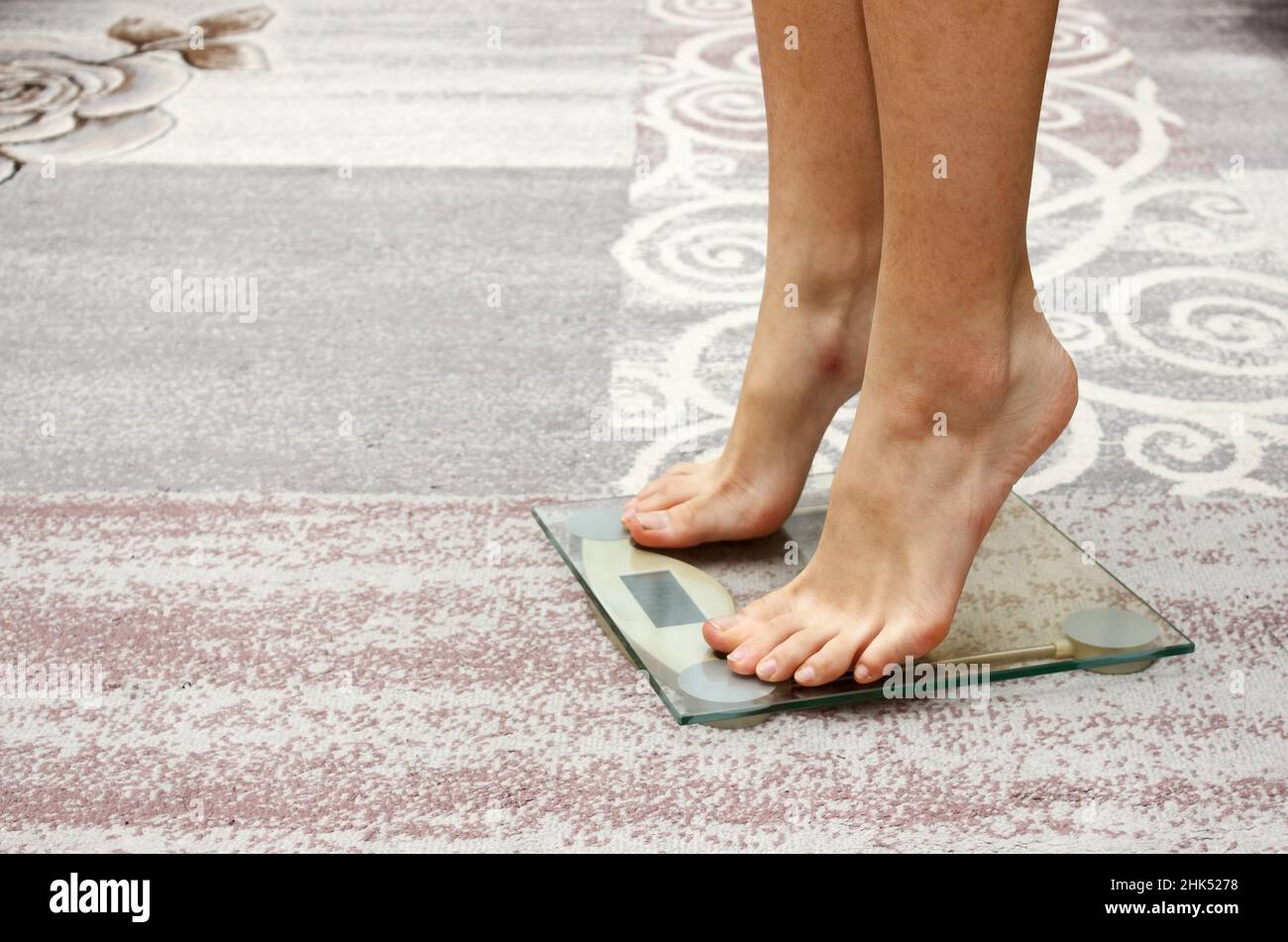 legs of a girl standing on the scales. indoor closeup Stock Photo - Alamy