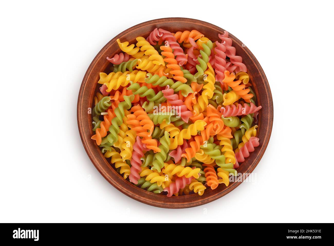 raw Fusilli colored pasta in ceramic bowl isolated on white background ...