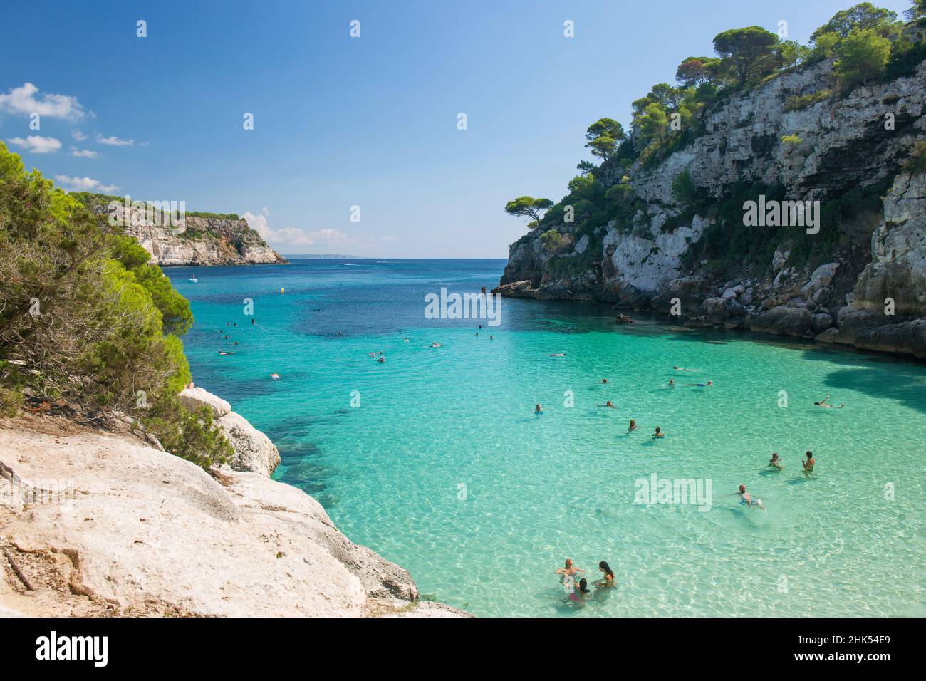 View over the turquoise waters of Cala Macarelleta to pine-clad ...