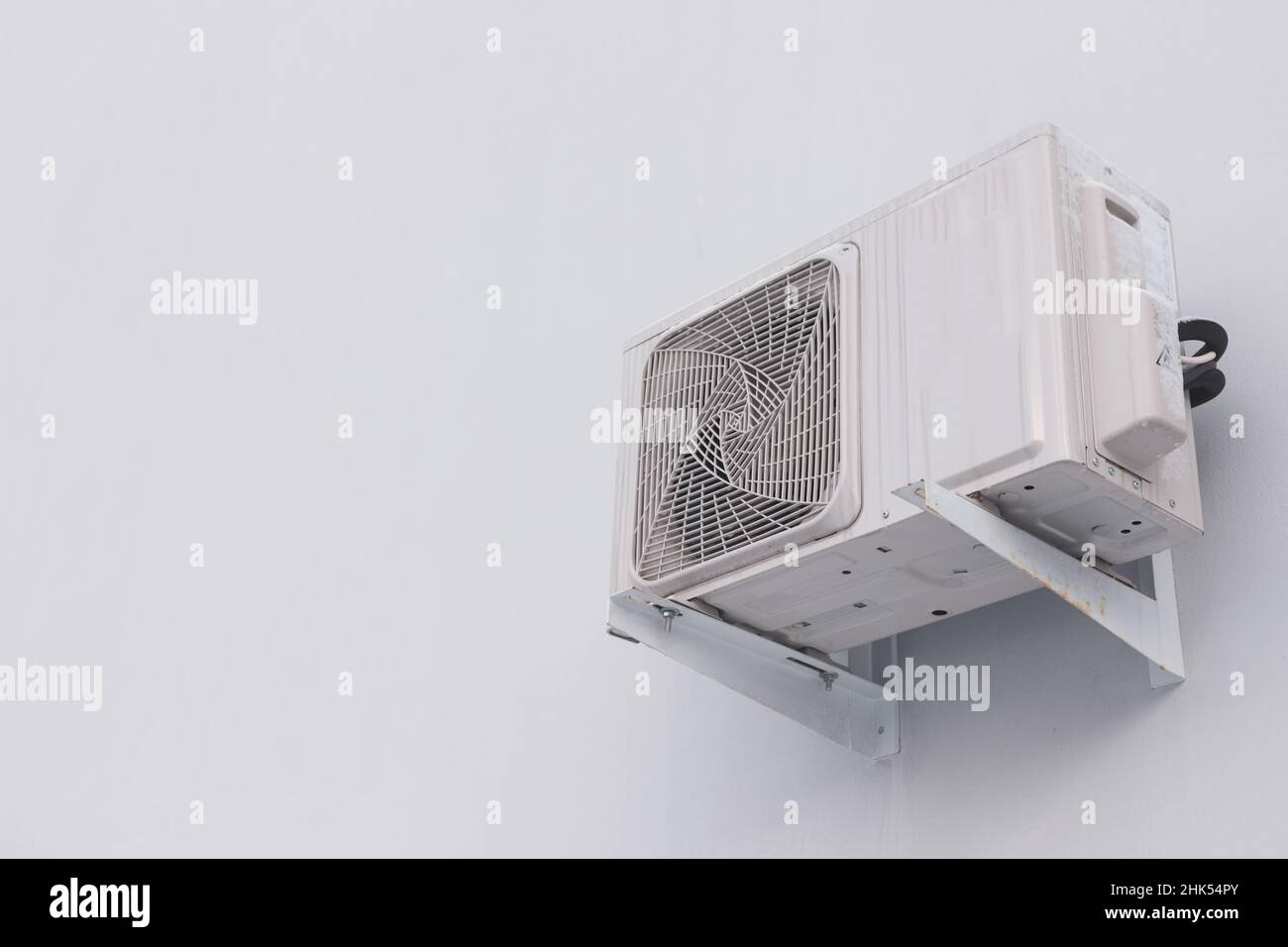 Outdoor air conditioner split system unit on white wall with copy space ...